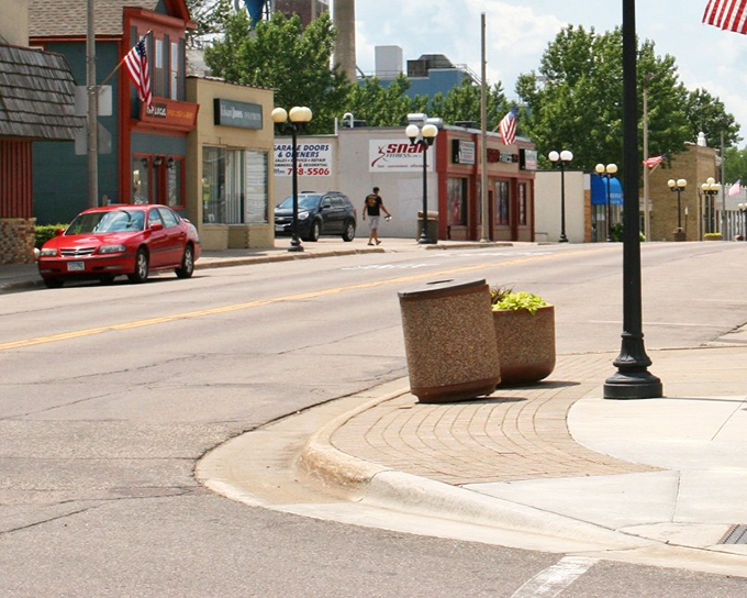Corner planters and vintage streetlights add charm to the shopping district, where local businesses have resisted the homogenization of American retail.