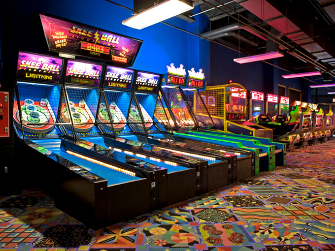 The arcade's neon lights create an electric atmosphere where skee-ball champions and video game wizards can test their skills between water adventures.