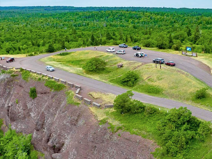 From above, the parking area clings to the cliff edge, where visitors gather to witness Superior's endless blue horizon.