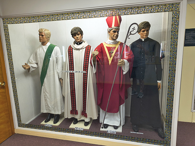 These life-sized figures display the progression of Catholic clergy, from altar server to bishop, each with their distinctive ceremonial vestments.