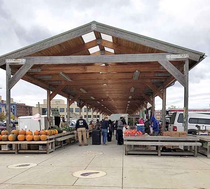The outdoor pavilion extends the market experience, offering seasonal treasures under rustic wooden beams that frame Michigan's changing skies.