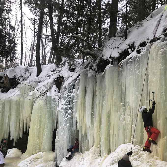 Daring ice climbers scale the frozen curtains, adding human drama to nature's stage in this Upper Peninsula winter theater.
