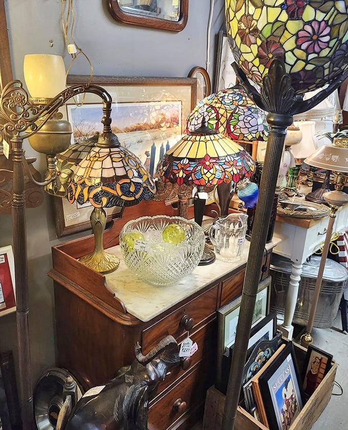 Tiffany-style lamps cast kaleidoscope patterns across the room, their stained glass petals and dragonflies transforming mere illumination into atmospheric magic.