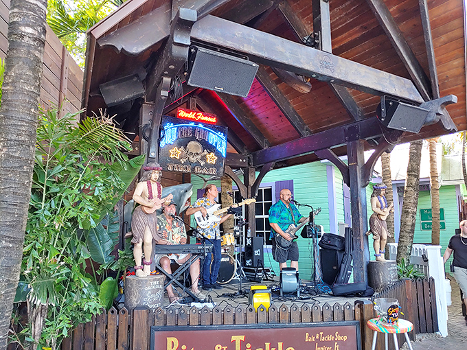 Live music sets the soundtrack for sunset, as musicians create the perfect island vibe beneath carved tiki guardians.