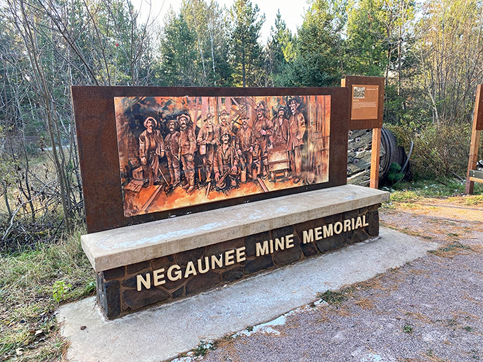 The Negaunee Mine Memorial stands as a solemn tribute, where weathered images honor those who descended into darkness so America could rise.