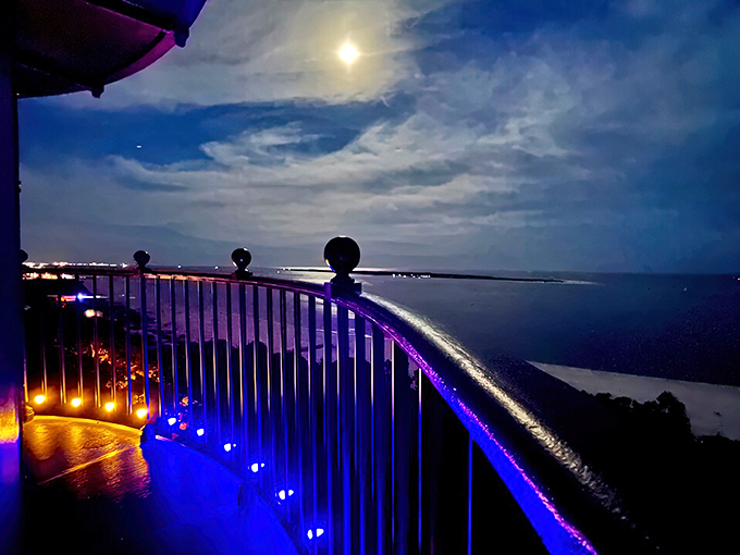 As darkness falls, the lighthouse transforms into a magical beacon, its gallery illuminated with the blue and purple hues of evening.