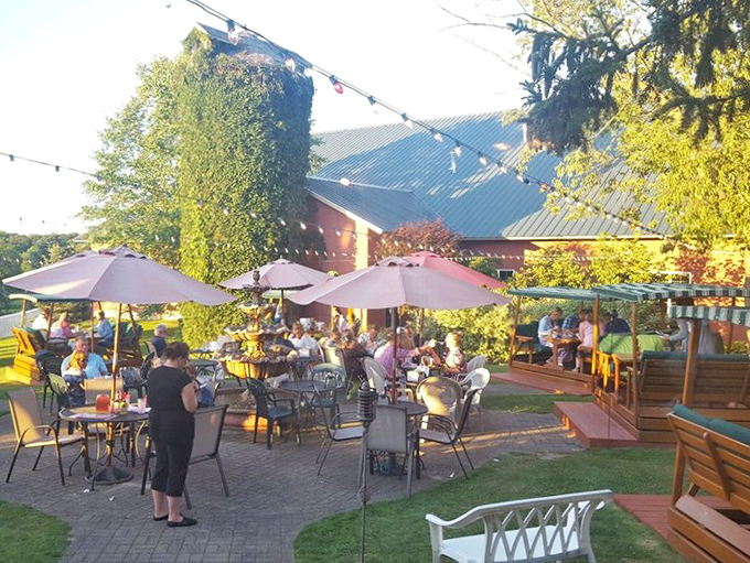 The outdoor patio transforms into a magical garden at dusk, string lights twinkling overhead as diners linger over dessert and conversation.