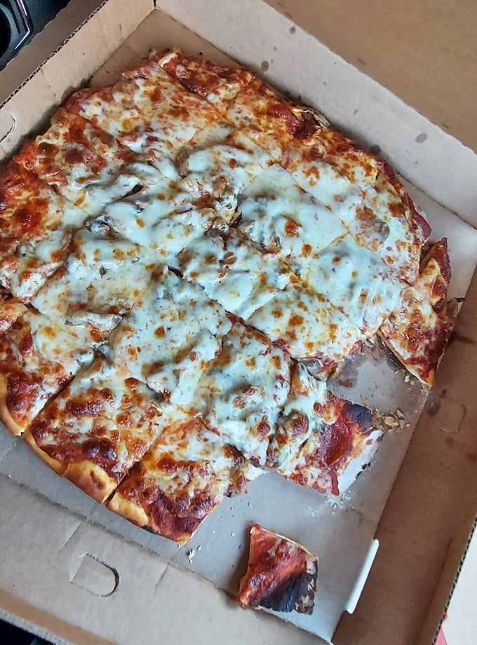 This perfectly cut, cheesy pizza is waiting right in the box. That delicious, bubbling topping is calling your name for a slice!