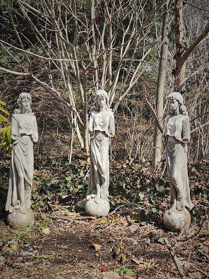 Silent stone figures stand watch in the garden, their weathered faces hinting at secrets they've witnessed throughout the castle's storied history.