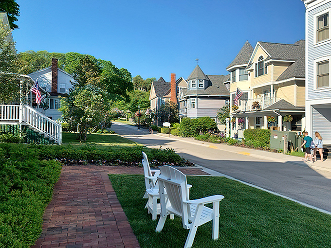 Street-Side Lawn View: White Adirondack chairs dot emerald lawns along this car-free street where time moves at the pace of passing carriages.