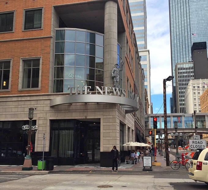 Downtown Minneapolis provides the backdrop for The News Room's outdoor seating &ndash; urban energy meets culinary creativity under Minnesota's summer skies.