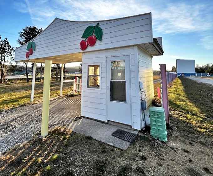 The ticket booth stands sentinel, its cherry decorations promising sweet entertainment ahead. First-timers become lifelong patrons here.