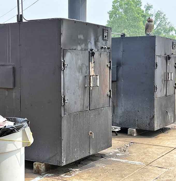 Heavy-duty smokers stand like sentinels outside, their weathered exteriors telling stories of countless briskets transformed within their chambers.