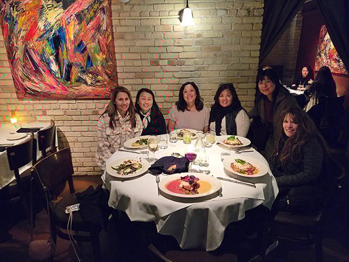 Happy diners gathered around a table laden with Italian delights &ndash; the universal language of good food bringing people together.