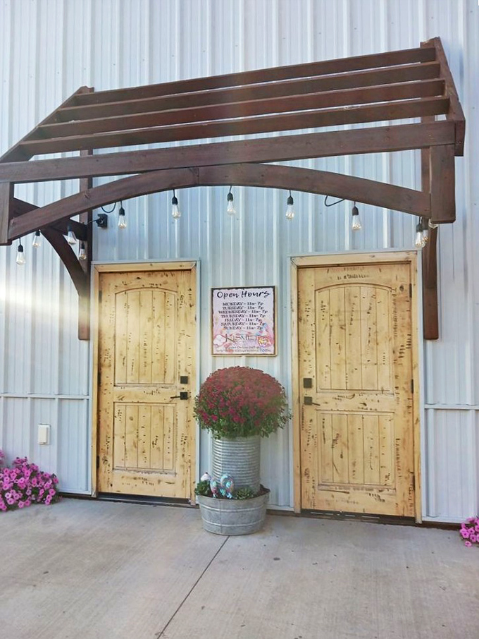 Rustic wooden doors framed by a charming pergola create an inviting entrance to this sugar wonderland, complete with seasonal flowers in a galvanized planter.