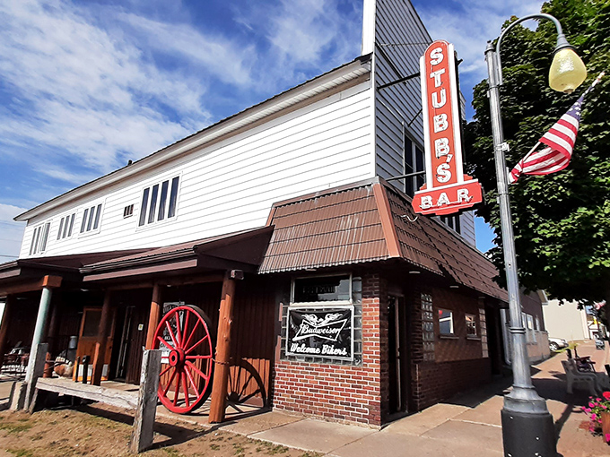 By daylight, Stubb's exterior reveals its charming blend of small-town Americana, complete with wagon wheel, brick facade, and welcoming entrance.