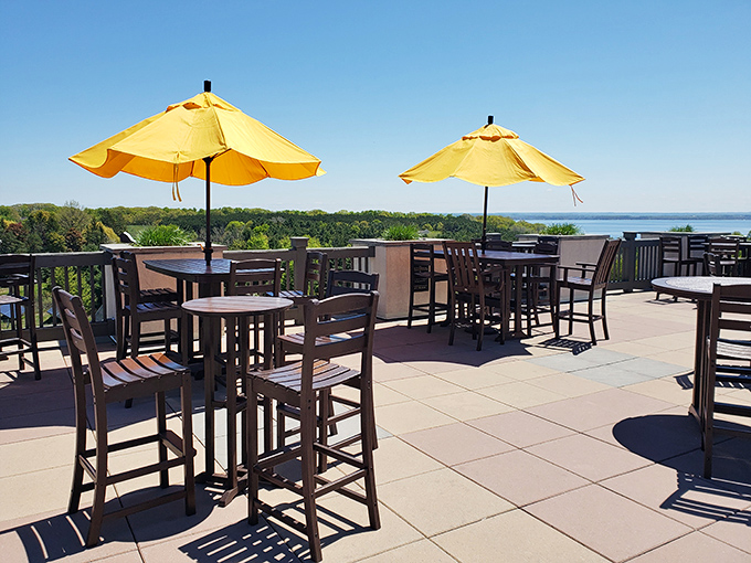 The elevated patio dining area offers unobstructed views of the peninsula, with cheerful yellow umbrellas providing just enough shade.