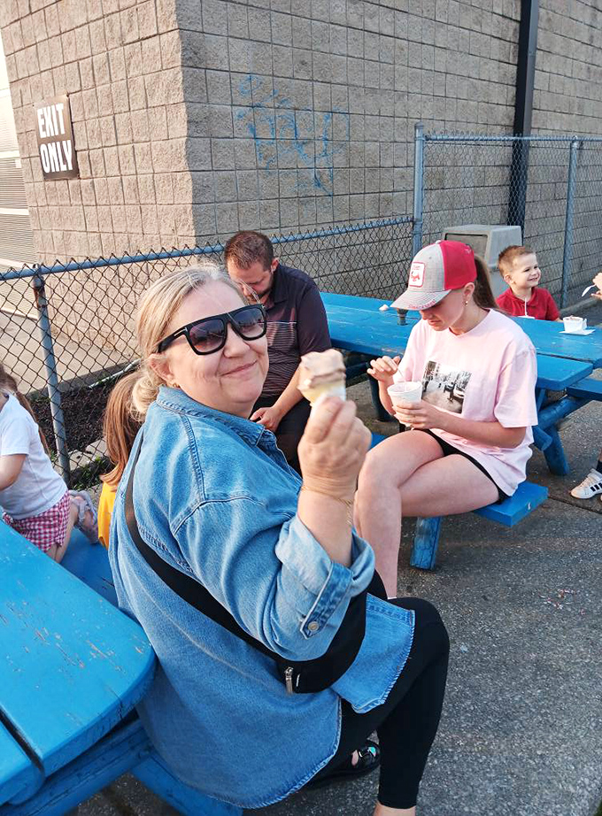 Blue picnic tables become community gathering spots where strangers share smiles and strategies for catching drips.