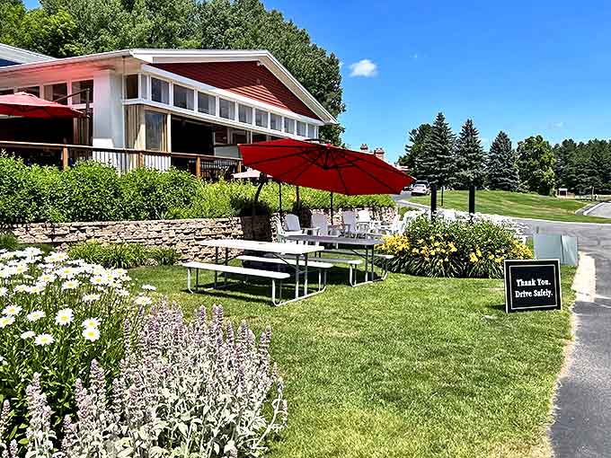 The outdoor patio invites lingering on sunny afternoons, with umbrella-shaded tables nestled among blooming gardens and vineyard views.