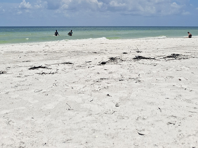 The shoreline stretches toward infinity, where turquoise waters meet cloudless skies in a horizon that calms the soul.