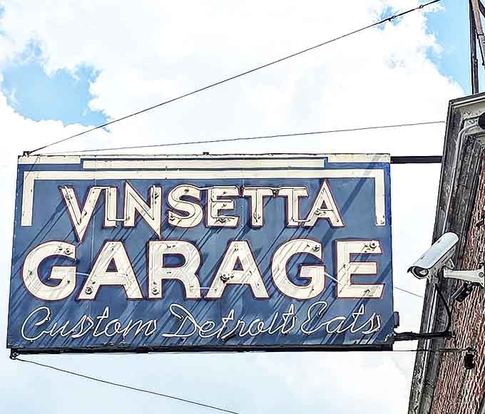Signage: The blue and white "Vinsetta Garage" sign promises "Custom Detroit Eats" &ndash; a perfect blend of automotive heritage and culinary creativity against the Michigan sky.