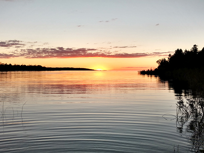 Lake Huron's sunset performance turns the water into liquid gold, creating the kind of moment that makes you forget to check your phone.