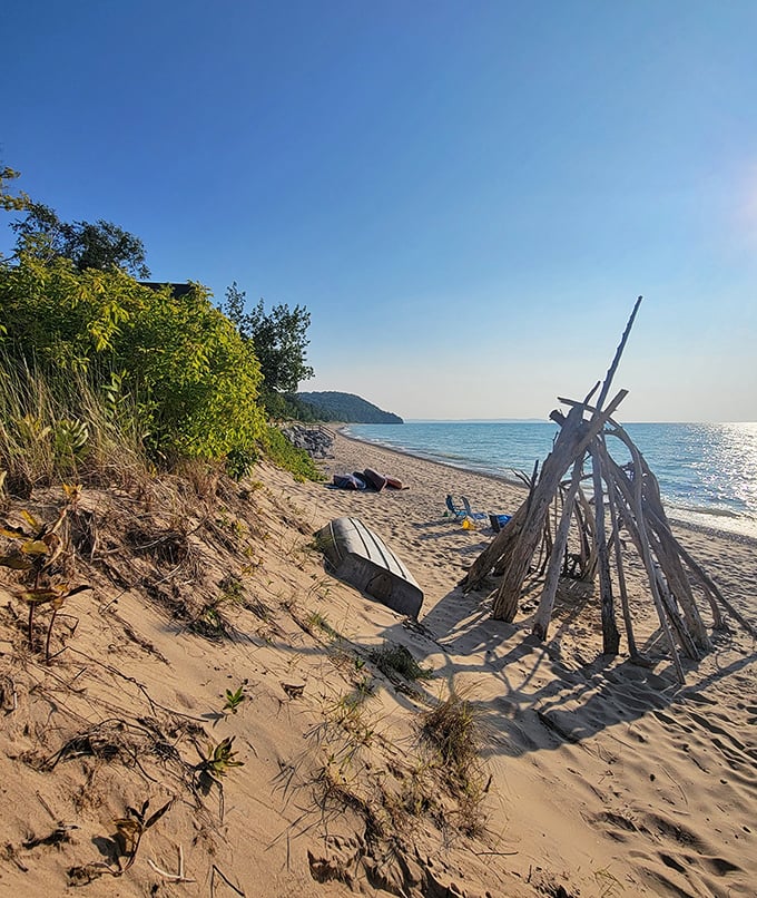 Driftwood structures dot the shoreline like temporary art installations, evidence of creative spirits inspired by this natural canvas.