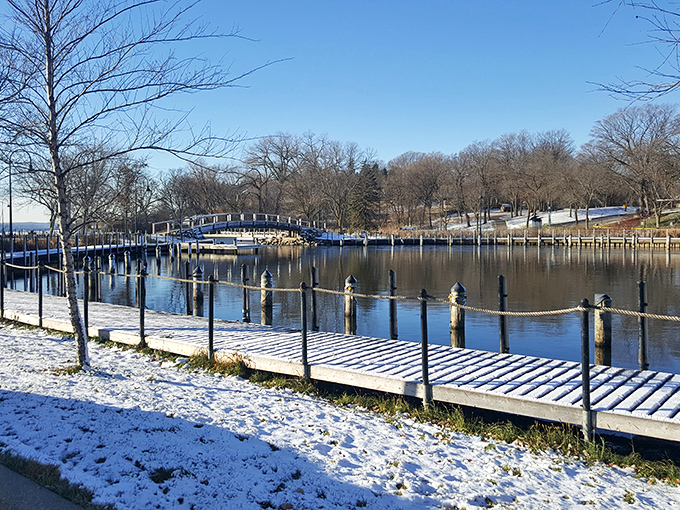 Winter transforms the marina into a serene snowscape, where boats sleep under white blankets until spring's gentle awakening.