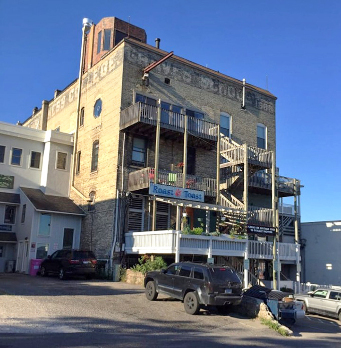 Back Entrance: The historic building housing Roast & Toast reveals its character from every angle, with outdoor seating perfect for summer mornings.