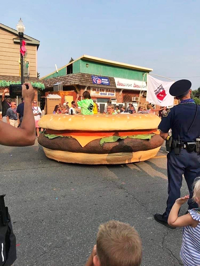Police officers maintain order while secretly wishing they could trade their uniforms for Hawaiian shirts during the burger float procession.
