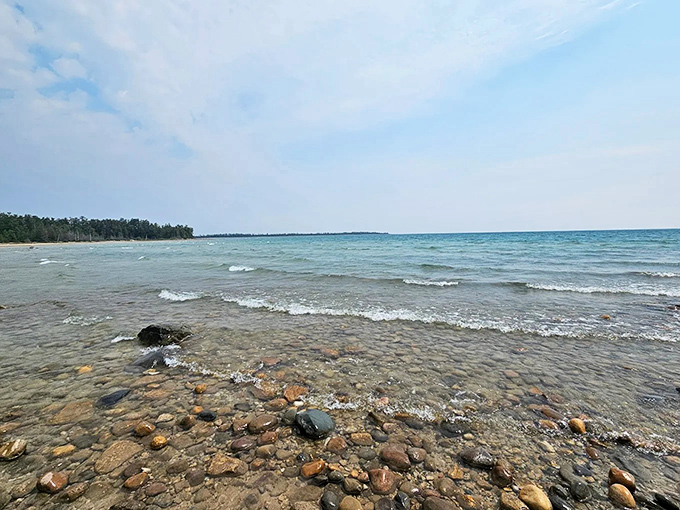 Lake Huron's crystal-clear waters lap against the rocky shoreline, creating a timeless rhythm that predates and will outlast us all.