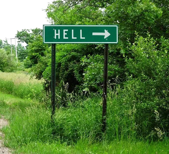 Directional signage points travelers toward Hell with cheerful certainty, making damnation seem like just another pleasant Michigan road trip destination.