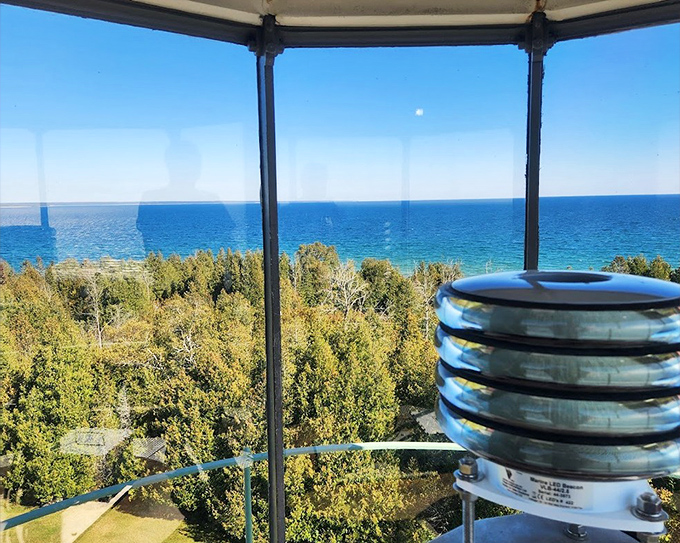 The lantern room's glass panels frame a spectacular Michigan view, where sky meets water in a horizon that seems to stretch into infinity.