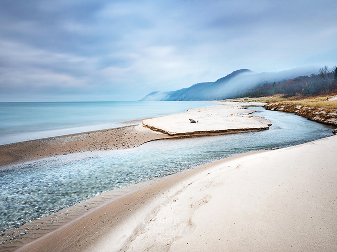 Morning mist clings to the shoreline like nature's own special effect, adding mystery to the already magical landscape.