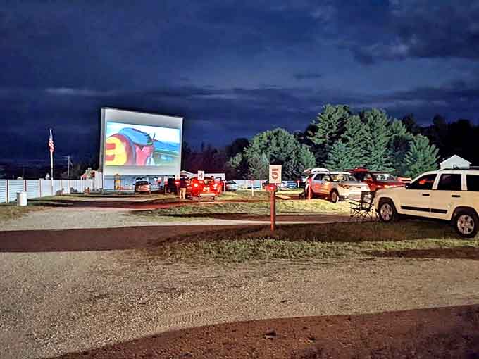 The screen illuminates the night as a movie plays. Hundreds watch together, yet each car contains its own private world.