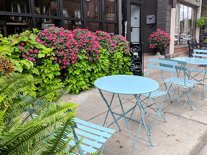 Cheerful blue tables surrounded by blooming flowers create a sidewalk oasis perfect for people-watching while contemplating how you'll walk off all those delicious calories.