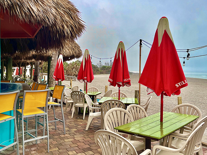 Even on a cloudy day, the beach vibe is strong! Find your sunny spot beneath a bright red umbrella and relax.