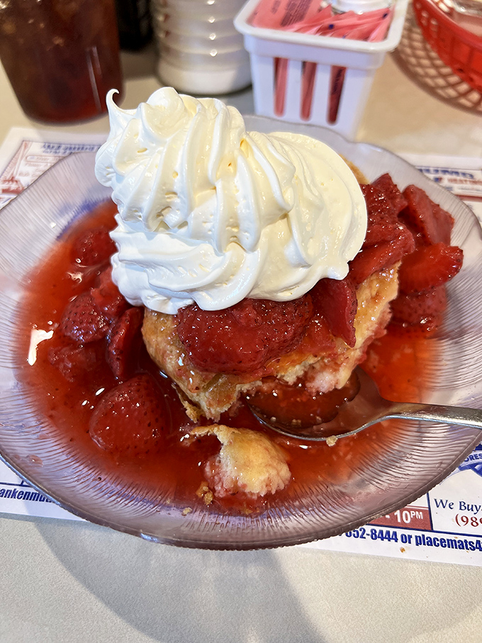 Strawberry shortcake that defies gravity – warm biscuit foundation, ruby-red berries, and a cloud of whipped cream that reaches for the heavens.