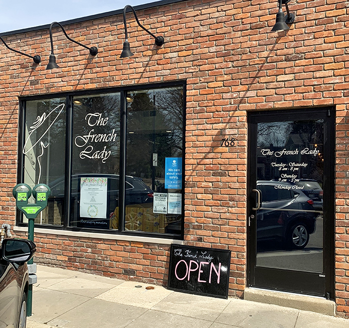 The inviting storefront with its simple "OPEN" sign promises culinary transportation to France, right in the heart of Birmingham, Michigan.