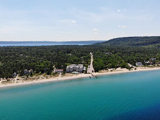 From above, Lake Street Beach reveals its true splendor: a perfect crescent of sand embraced by forests and crystal waters.