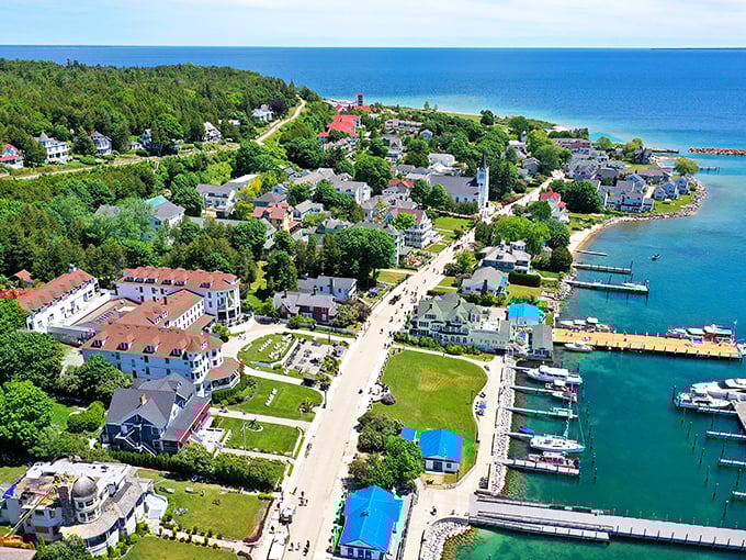 This aerial view captures Mackinac's perfect horseshoe harbor embraced by colorful Victorian buildings, revealing why generations of visitors fall in love at first sight.