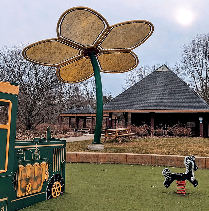 The flower sculpture provides shade and whimsy in equal measure, proving that functional art is the best kind of playground magic.