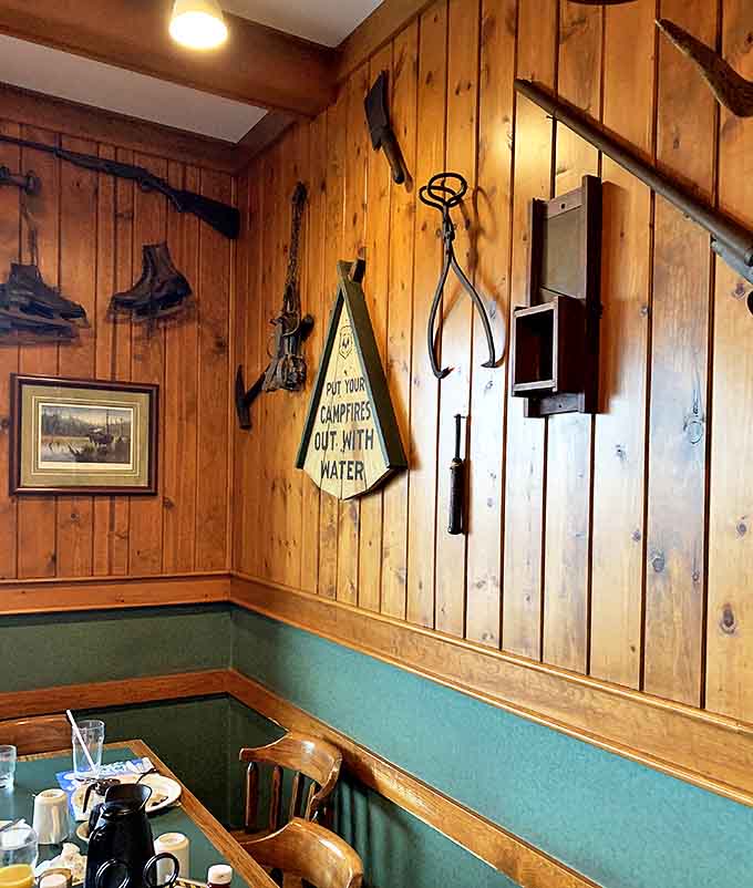 Vintage hunting gear and forest service signs transform ordinary walls into a nostalgic North Woods time capsule.