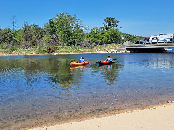 Kayakers glide across Hamlin Lake's mirror-like surface, creating ripples that expand outward like nature's own version of connect-the-dots.