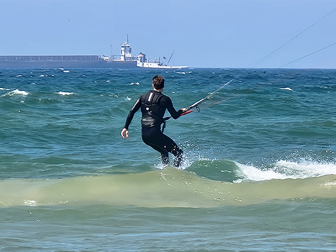 A wetsuit-clad kiteboarder harnesses twin powers of wind and wave, demonstrating that Lake Michigan's "inland sea" offers thrills worthy of any ocean coast.