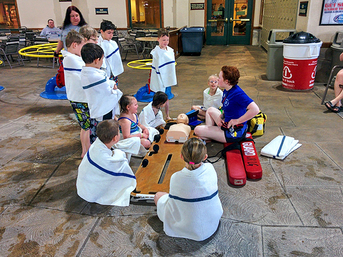 Future lifesavers gather for poolside training, wrapped in towels and rapt attention as they learn skills that combine fun with real-world importance.