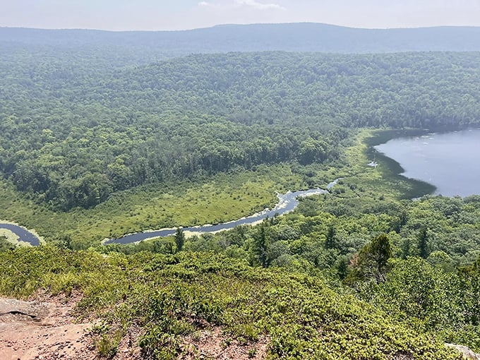 The winding river below resembles a blue ribbon carelessly dropped by a giant &ndash; nature's artistry on display at its most magnificent.