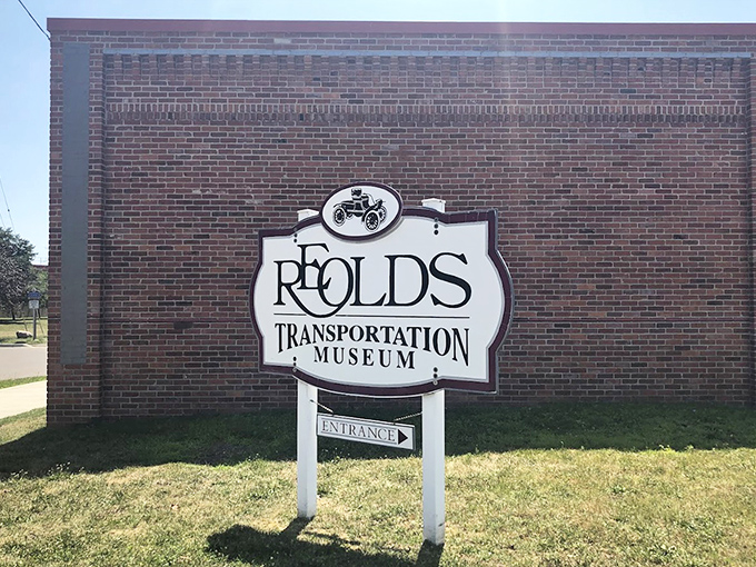 The distinctive R.E. Olds Transportation Museum sign stands as a beacon for automotive history buffs and curious travelers alike, promising mechanical wonders within.