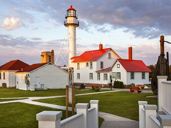 The iconic Whitefish Point Lighthouse stands sentinel against Lake Superior's fury, its white tower and red-roofed keeper's quarters preserving nearly two centuries of maritime history.