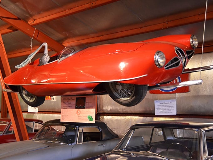 This sleek red Alfa Romeo looks ready for takeoff, suspended in mid-air like an automotive ballet frozen in time.